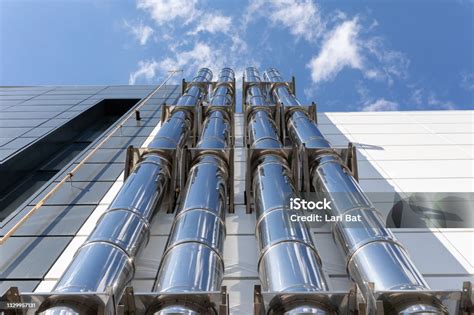 파란색 하늘 배경에 대한 흑백 산업 건물의 외부 벽에 크롬 환기 파이프 상향식 보기입니다 강철에 대한 스톡 사진 및 기타 이미지