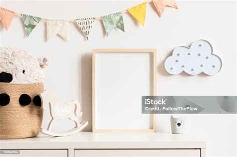 흰색 선반에 사진 또는 포스터 프레임을 모의 하 여 세련 되 고 현대적인 스칸디나비아 어린이 실내 장난감 바구니에 테 디 베어 말과 매달려 면 화려한 플래그와 구름을 흔들