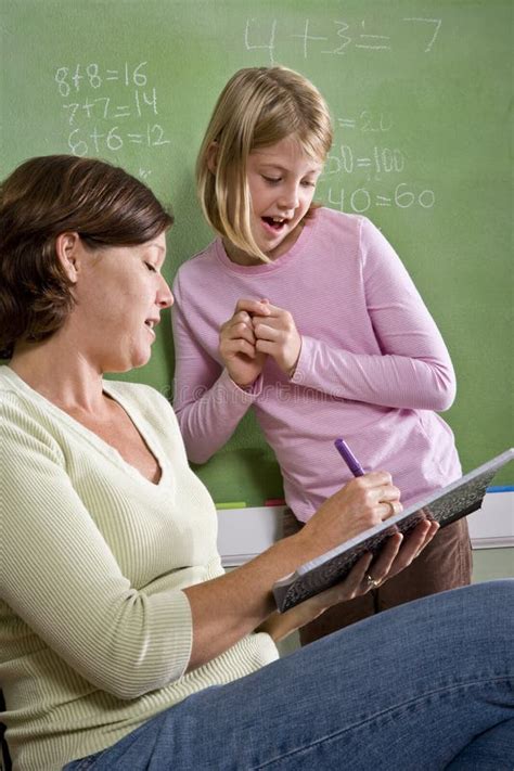 Schulen Sie Mädchen Und Lehrer Durch Tafel Im Klassenzimmer Stockfoto