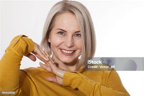 중 년 금발의 감정적으로 포즈 스튜디오에서 흰색 바탕에 노란 밝은 스웨터에 행복 한 여자 귀여운에 대한 스톡 사진 및 기타 이미지 귀여운 긍정적인 감정 표현 길이