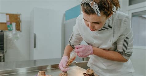 분홍색 장갑을 끼고 제과 스튜디오에서 크림과 신선한 딸기로 컵케이크를 만드는 여성 과자 장수의 클로즈업 사진 Unsplash의 케이크 이미지