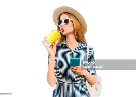 흰색 배경에 고립 된 밀짚 모자를 쓰고 신선한 주스를 마시는 스마트 폰을 가진 아름다운 젊은 여성의 여름 초상화 20 29세에 대한 스톡 사진 및 기타 이미지 Istock