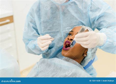 Dentist With Assistant Wearing Uniforms Making Medical Procedures