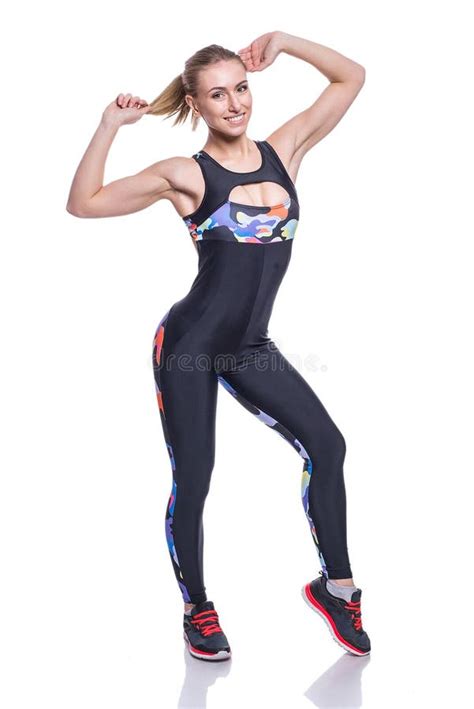 Милая атлетическая модельная девушка в Sportswear с гантелями в студии против черной предпосылки