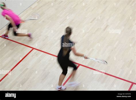 Two Female Squash Players In Fast Action On A Squash Court Motion Blurred Image Color Toned