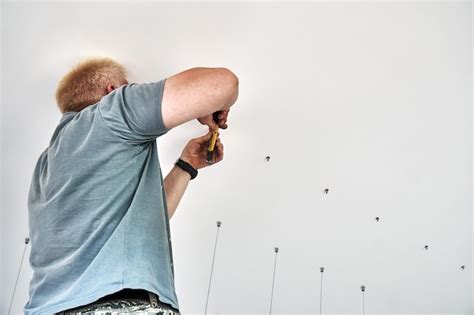 Premium Photo Electrician Mounting Ceiling Lamp In Modern Office