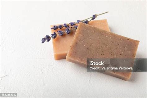 하얀 시멘트 배경에 라벤더 꽃이 있는 천연 라벤더 비누 수제 Soapessential Oilsspa 제품이 함유 된 화장품