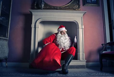 Santa Claus Coming Out Of The Chimney Premium Photo