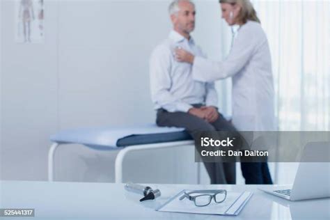 전경에 책상에 사무실 노트북 파일 안경 및 이경에서 환자를 검사 하는 여성 의사 백인종에 대한 스톡 사진 및 기타 이미지 백인종 사분의 삼 길이 책상 Istock