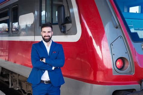 Retrato De Joven Conductor De Tren Barbudo En Uniforme Azul De Pie Con