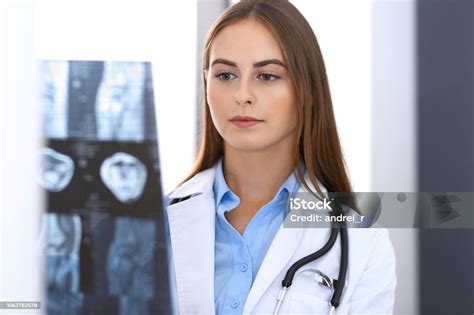 의사 여자 병원에 창문 가까이 서 있는 동안 X 선 사진 검사 외과 의사 또는 직장에서 정형 외과입니다 의학 및 건강 관리 개념입니다 X 레이에 대한 스톡 사진 및 기타