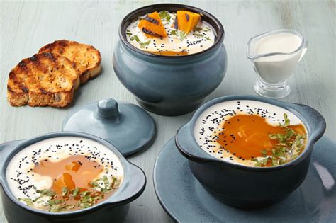 냄비와 그릇에 구운 조각 크루톤 우유를 곁들인 호박 가을 퓌레 수프 가스파초에 대한 스톡 사진 및 기타 이미지 가스파초