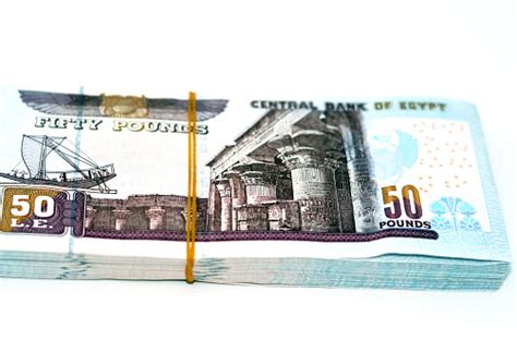 50 Le 오십 파운드 시리즈 2022의 이집트 돈 지폐 더미는 Edfu 사원 날개 달린 풍뎅이 및 파라오닉 보트의 이미지와 뒷면에 아부 Hurayba 모스크를 특징으로