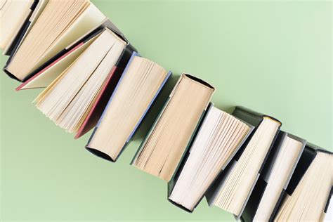 밝은 녹색 배경에 반대 쪽 모서리에 프레임의 한 쪽 모서리를 형성 각도에서 실행 끝에 서 책의 줄 0명에 대한 스톡 사진 및