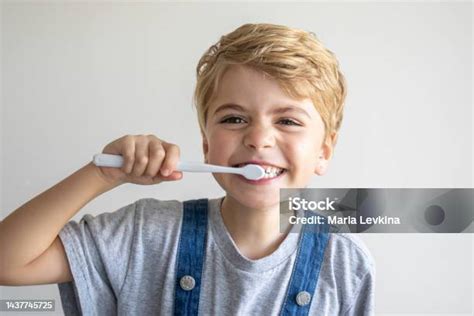 귀여운 아이가 칫솔을 닦고 흰색 배경 위에 웃고 있다 스튜디오 촬영 치과 위생 아침 일과 생활 습관 치아 관리 어린이 건강 아이에 대한 스톡 사진 및 기타 이미지 Istock