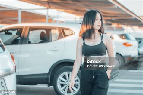 주차장에서 걷고 있는 검은 탑에 어깨 길이의 머리를 가진 아름다운 백인 소녀 검은색에 대한 스톡 사진 및 기타 이미지 검은색 관능 나이 Istock