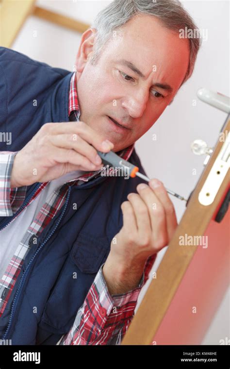 Senior Man Screwing Lock Into Door Stock Photo Alamy