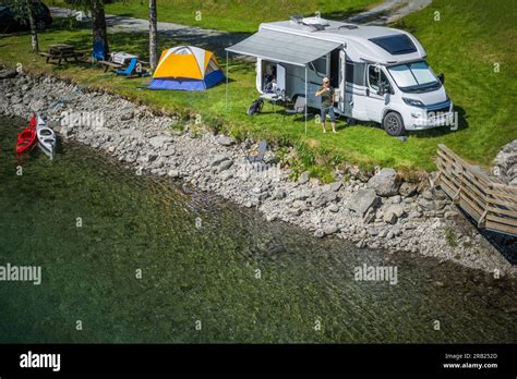 Aerial View Of Motorhome Traveler Enjoying Coffee In Front Of His Rv After Setting Up A Campsite