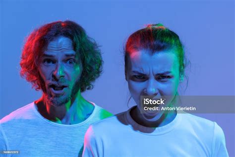 네온 라이트의 파란색 배경 위에 고립 된 흰색 티셔츠를 입고 포즈를 취하는 젊은 남녀의 초상화 감정적인 표현 20 24세에 대한 스톡 사진 및 기타 이미지 Istock