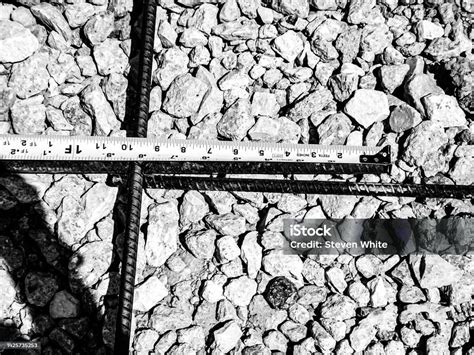 Inspecting And Documenting The Rebar Overlap With A Measuring Tape At A Construction Job Site