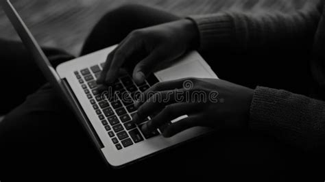 African Adult Man Typing On Laptop Keyboard In Black And White Stock
