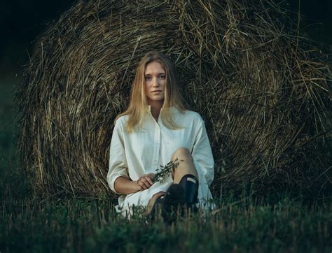 Обои на рабочий стол Девушка с длинными волосами в белом платье сидит у стога сена обои для