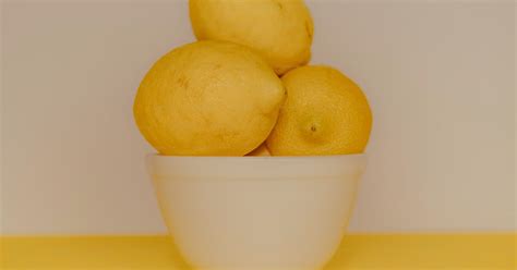 노란 테이블 위에 놓인 레몬 한 그릇 사진 Unsplash의 과일 이미지