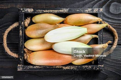 노란 샬롯 양파 나무 상자에 두 개의 반으로 잘라 검은 색 나무 배경 위쪽 보기 0명에 대한 스톡 사진 및 기타 이미지 0명