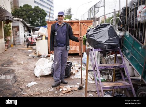 Finding Gems In The Dirt A Man Sorting Through Garbage At A Dumping