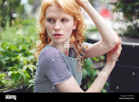 Ginger Girl In Green Bush On Street Photo Toned Stock Photo Alamy