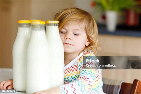 사랑 스러운 유아 여자 아침 식사 암소 우유를 마시는 병이 많은 귀여운 아기 딸 건강 한 아이 칼슘 소스로 우유를가지고 아침에 집 이나 보육원에서 아이 가정 주방에 대한
