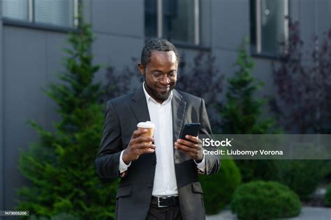 커피 브레이크 사무실 근처에 있는 젊은 아프리카계 미국인 사업가 그는 커피와 전화를 들고 있습니다 커피 마실 것에 대한 스톡 사진 및 기타 이미지 Istock