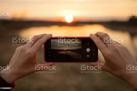 스마트폰을 클로즈업한 여자의 손 여행 중에 스마트폰으로 사진을 찍습니다 강 근처의 일몰 카메라에 대한 스톡 사진 및 기타 이미지 카메라 강 경관 Istock