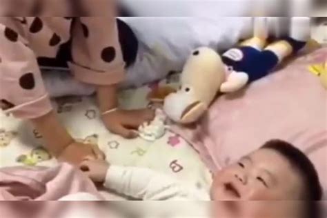 姐姐打弟弟一下，弟弟像被施了魔法一样笑得很开心，太可爱了！