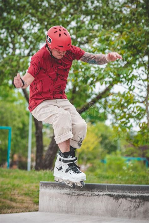Vertical Closeup Of An Inline Skater In A Skating Rink Practicing Moves With Trees In The