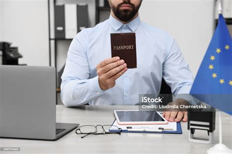 유럽 연합으로의 이민 사무실의 나무 테이블에서 여권 태블릿 및 문서를 들고 있는 대사관 직원 클로즈업 25 29세에 대한 스톡 사진 및 기타 이미지 Istock