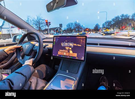 Woman Driving Tesla Model Y Through City At Dusk With Navigation And Traffic Data Displayed On Woman Driving Tesla Model Y Through City At Dusk With Navigation And Traffic Data Displayed On