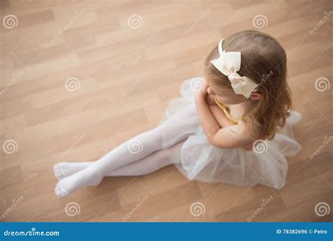 Pretty Diligent Ballet Girl Sitting In White Tutu At Dance Studio Stock