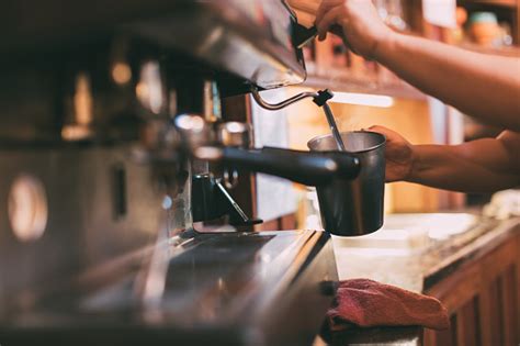 젊은 바리스타 만들기 라떼 에 A 고전적인 이탈리아 어 에스프레소 기계 가열 우유 갈색에 대한 스톡 사진 및 기타 이미지