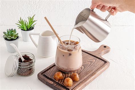 금속 용기에서 나온 우유 한 줄기가 얼음처럼 차가운 커피 한 잔에 부어집니다 커피를 저장하기위한 캔 맛있는 음료의 준비 0명에 대한 스톡 사진 및 기타 이미지 Istock