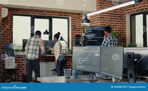 System Developers Analyzing Code On Wall Screen Tv Looking For Errors