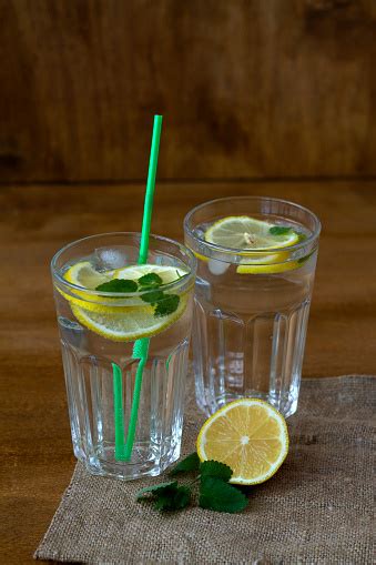 라임과 민트와 칵테일여름 음료 레몬과 신선한 잎 민트레모네이드 한 잔 소박한 나무 배경에 자루천이있는 수제 차가운 상쾌한 음료