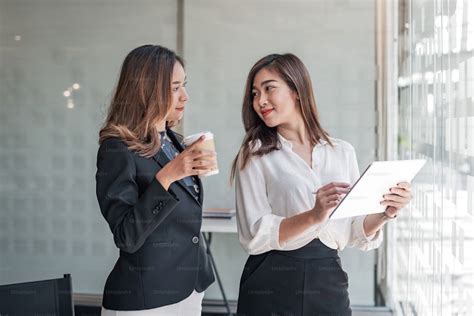 두 명의 젊은 아시아 사업가가 사무실에 놓인 종이와 태블릿을 사용하여 프레젠테이션 작업을 하고 있습니다 사진 Unsplash의 아시아 이미지