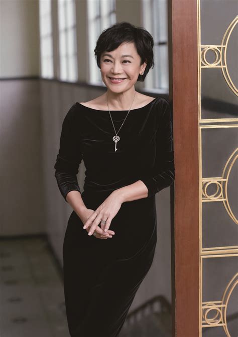 A Woman In A Black Dress Leaning Against A Door With Her Hand On The Side