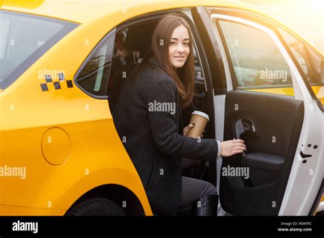 Young Cute Brunette Woman Holding Coffee In Backseat Of Taxi Stock