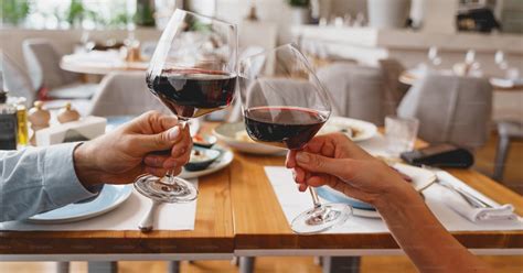 남성과 여성의 손이 배경에 나무 카페 테이블과 함께 알코올 음료 잔을 부딪히는 클로즈업 사진 Unsplash의 적포도주 이미지