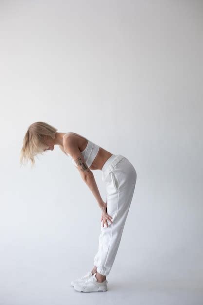 Une Belle Fille Blonde Dans Un Haut Blanc Et Des Collants Posant Sur Un