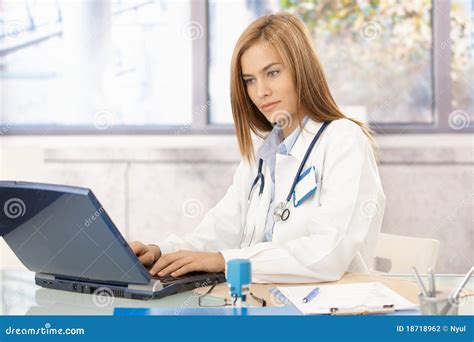 Junger Doktor Besetzt Im Büro Unter Verwendung Des Laptops Stockfoto