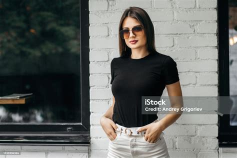 검은 색 티셔츠와 안경을 쓰고 거리 도시 의류 스타일에 대해 포즈를 취하는 세련된 갈색 머리 소녀 거리 사진 20 24세에 대한 스톡 사진 및 기타 이미지 Istock