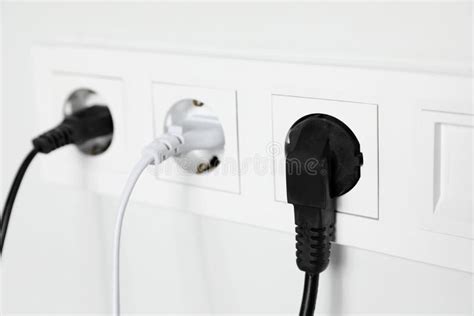 Power Sockets With Inserted Plugs On White Wall Closeup Electrical Supply Stock Image Image